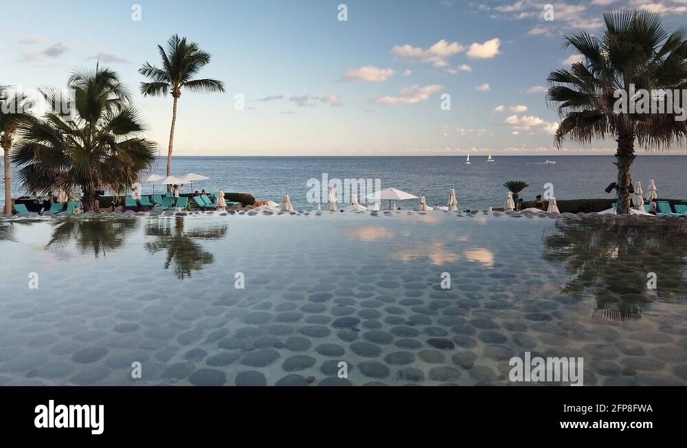 Water rippling in hotel resort infinity pool with ocean backdrop Stock ...