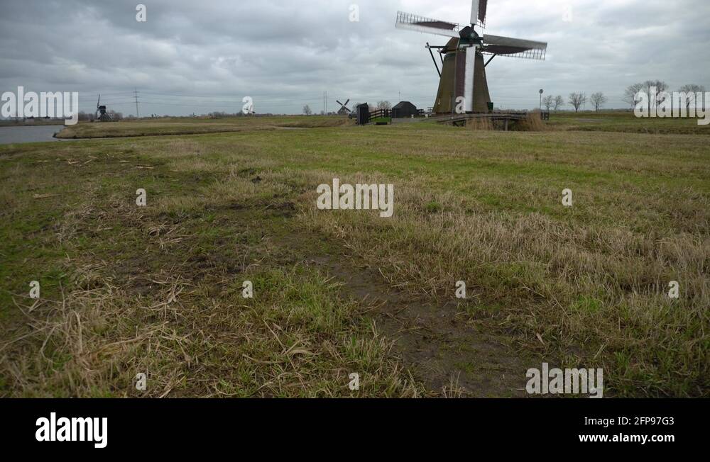 Dutch windmill turning fast in strong winds, camera tilt up reveal ...