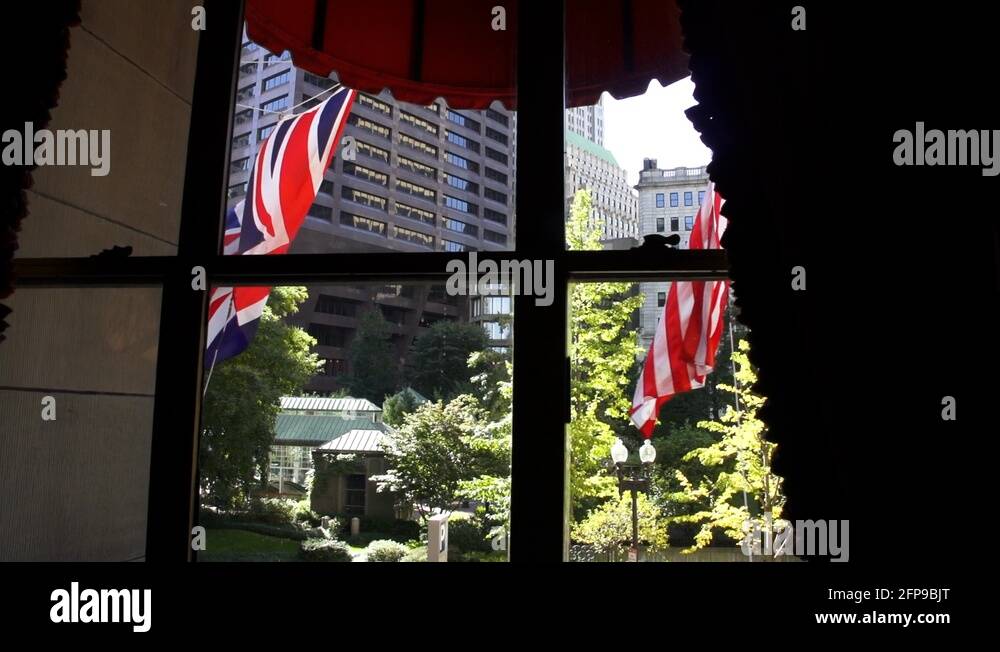 Union Jack and American flag flutter in the wind as seen through a ...