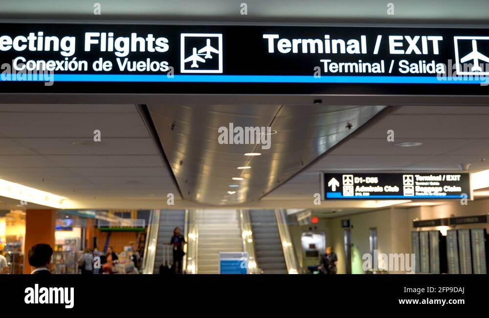 Trucking shot to left of airport signage for terminal exit and ...