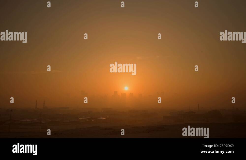 Wide view of Doha West Bay in Qatar during a hazy sunrise with sun ...