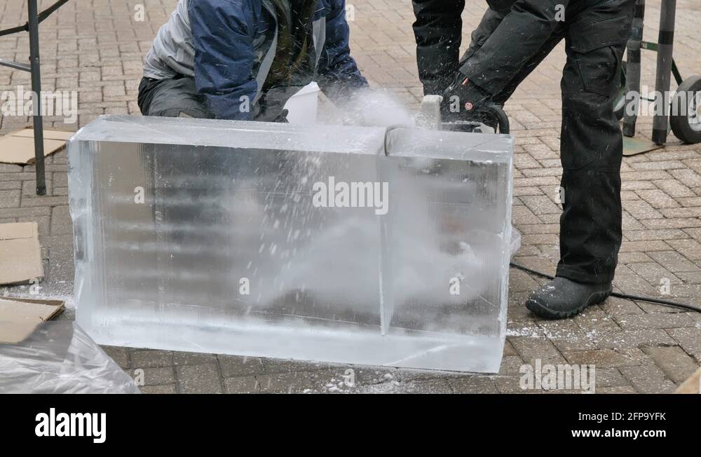 Ice sculptor cutting block with chainsaw. Slomo static shot Stock Video ...