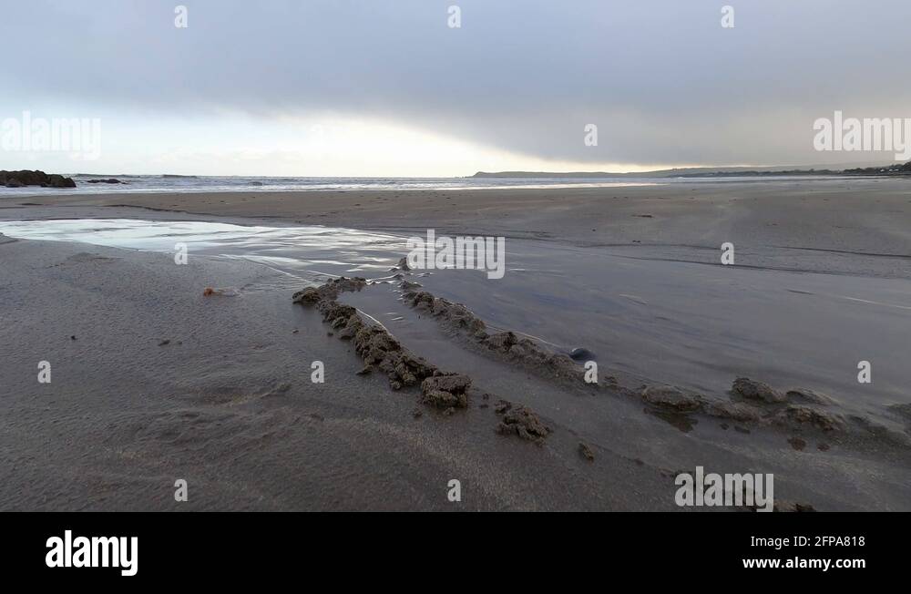 Wide angle of empty beach near ocean during cloudy day Stock Video ...