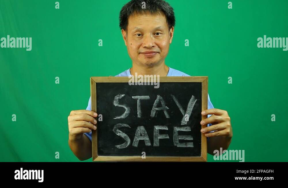 Man showing stay safe board with green background, in door Chiangmai ...