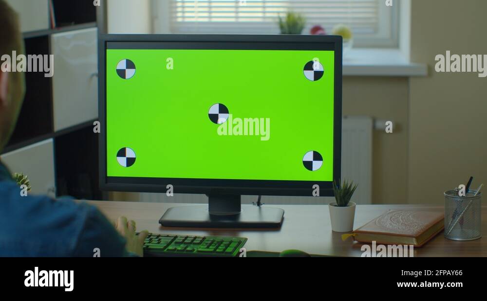 Male Video Editor Works on His Personal Computer with Big Green Screen ...