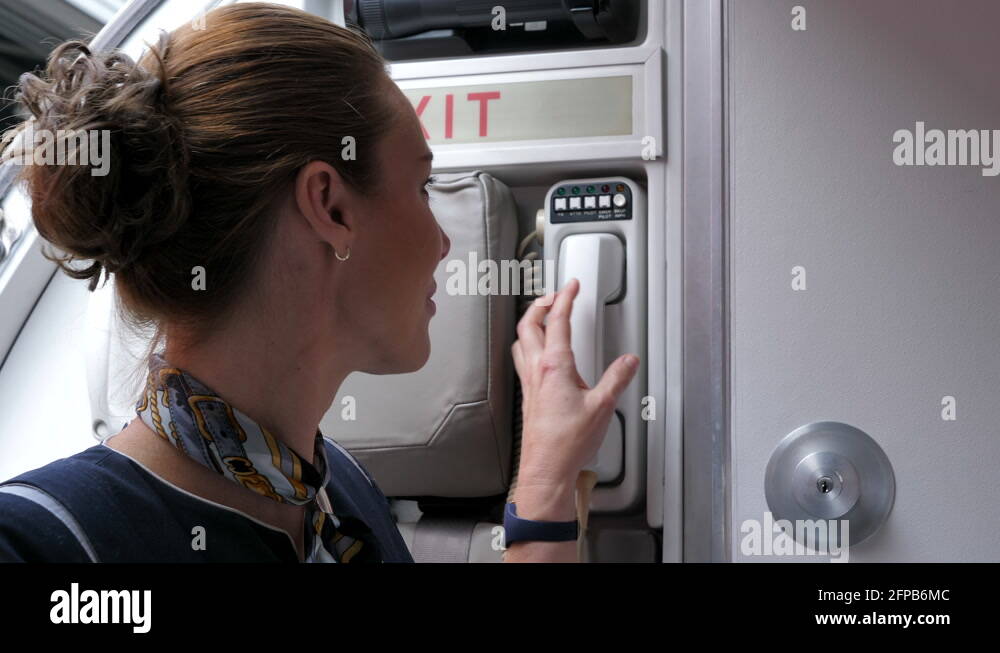Close Up Flight Attendant Speaking in Handset Telephone in Aircraft ...