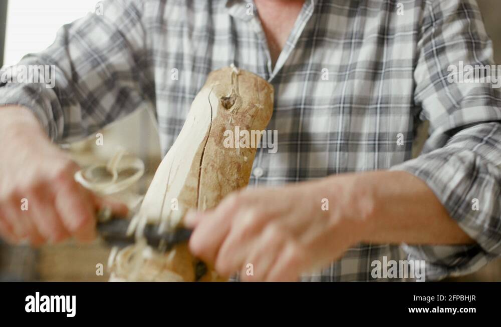 Carpenter uses two-handed plane to plane wooden workpiece. Joiner ...