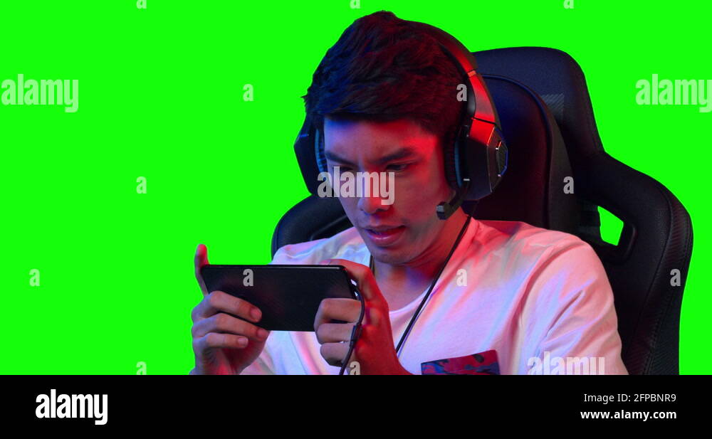 Pro cybersport gamer play online mobile game over green screen ...