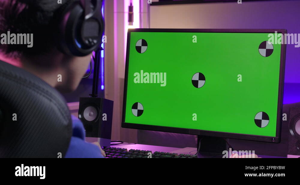 Cyber sport gamer playing online video game with green screen monitor ...