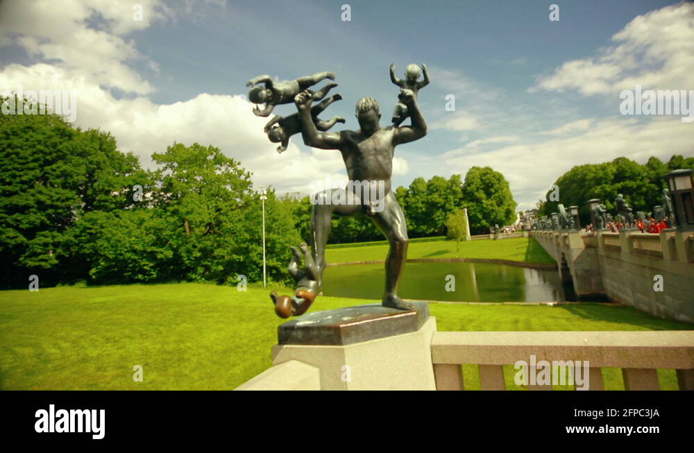 Statue of naked man and children falling from his arms on railing in ...