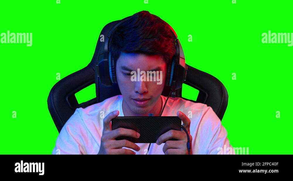 Pro cybersport gamer play online mobile game over green screen ...
