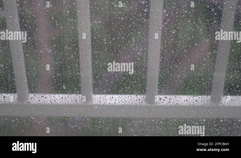Raindrops Dripping On The Surface of Glass Window on blury background ...