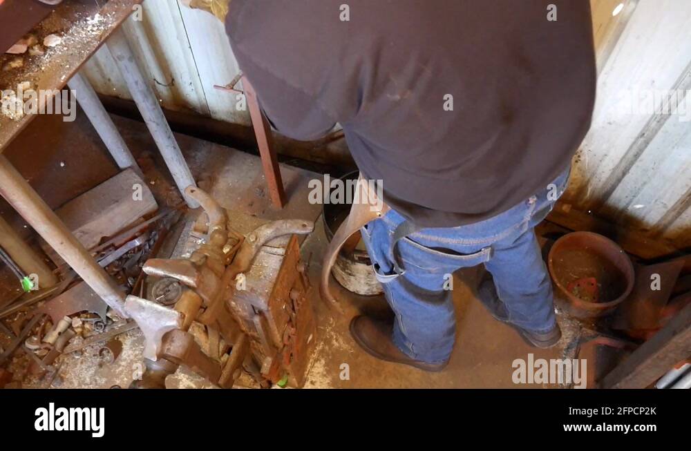 A Blacksmith Quenching a Hammer Head in Oil to Harden and Temper It in ...