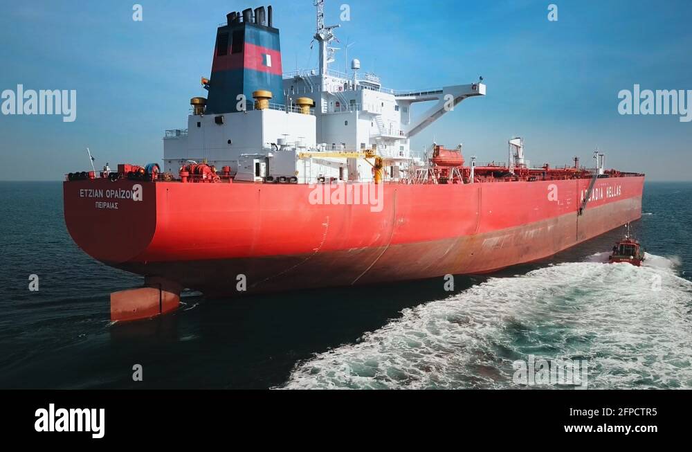 Oil Tanker and a pilot boat underway towards open sea. Aerial back view ...