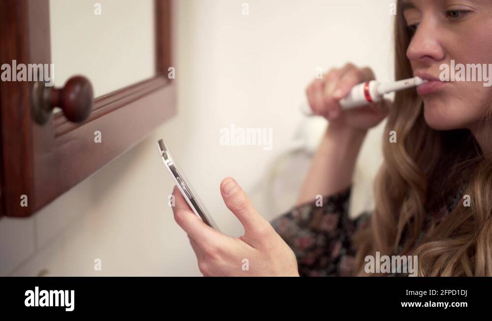 Using smart phone brushing teeth in bathroom Stock Videos & Footage ...