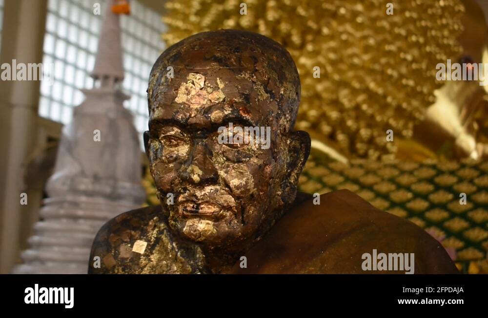 Flakey gold Buddhist statue in storage in Thailand, rotating close up ...