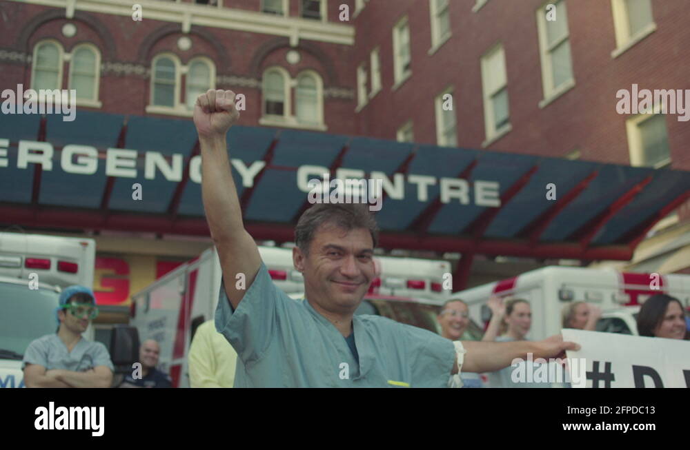 A group of ems staff are standing outdoors holding signs Stock Video ...