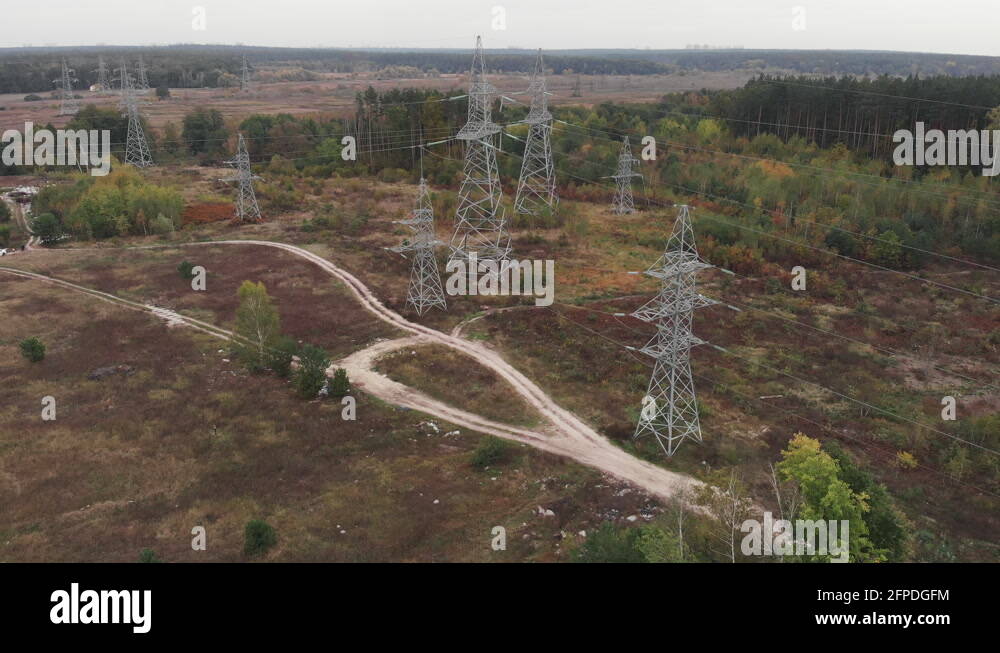 Long distance transmission lines. High-voltage pillars in forest. Power ...