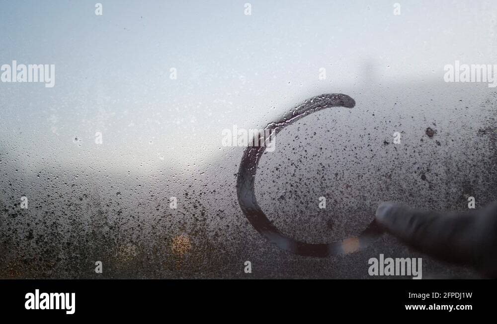 Hand drawing sad face on foggy window glass with condensation Stock ...