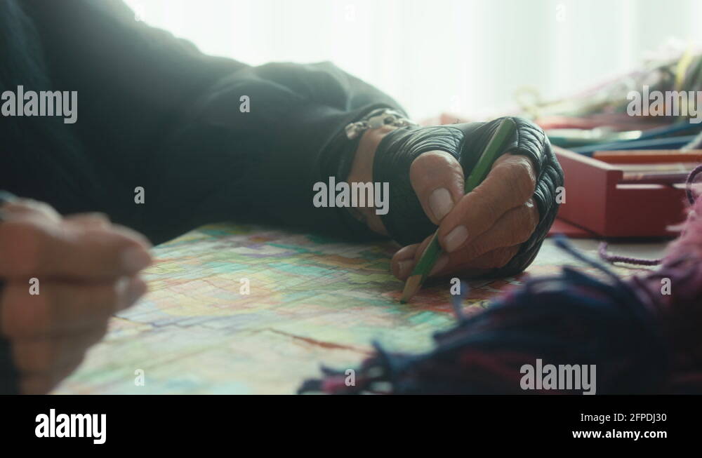Woman using a color pencil to draw a complicated sweater knitting ...