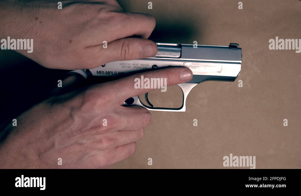 Close up shot of hands racking round into 9mm gun. Loaded pistol Stock ...