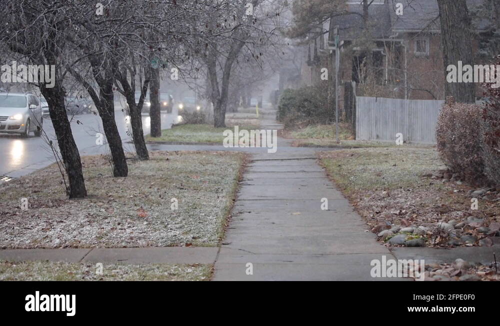 Snow Falling on Sidewalk of Residential Neighborhood as Cars Speed By ...