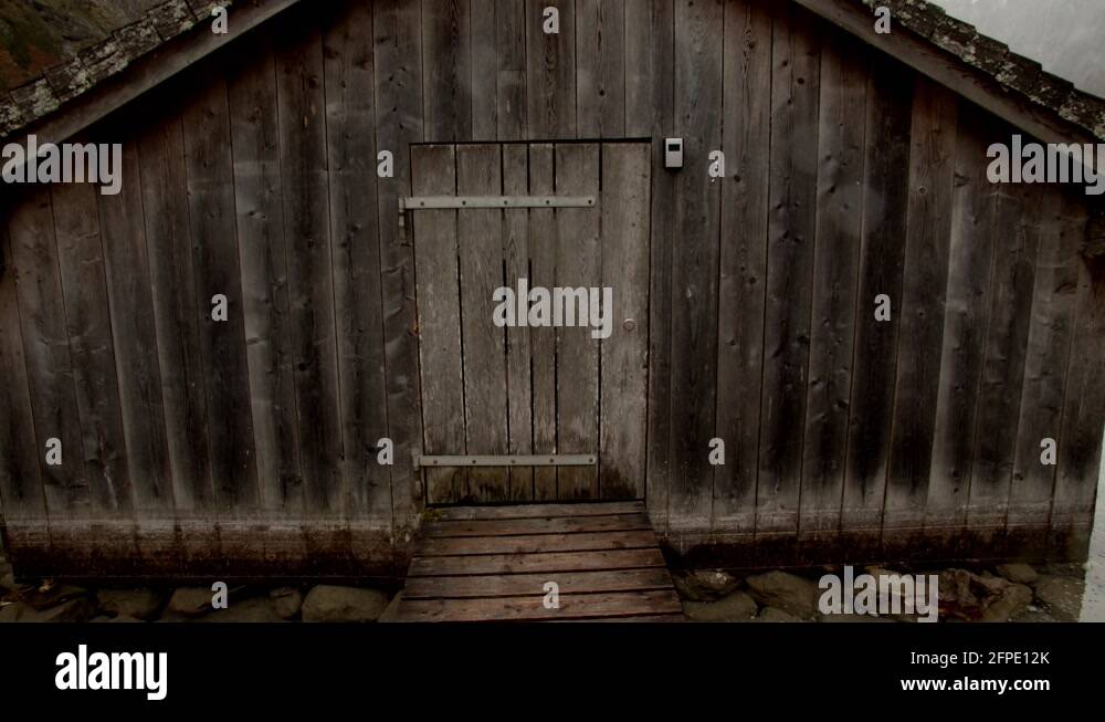 Reveal tilt up shot of an old wooden cabin in the lake konigssee Stock ...