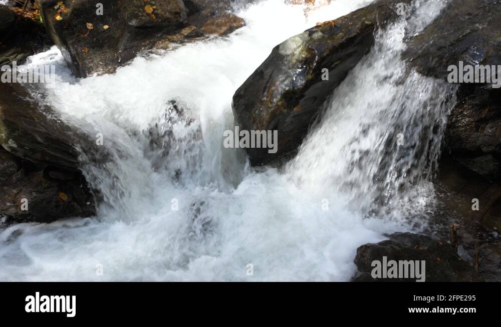 Water flows over rocks in small waterfalls in river pool, 4k, 60fps ...