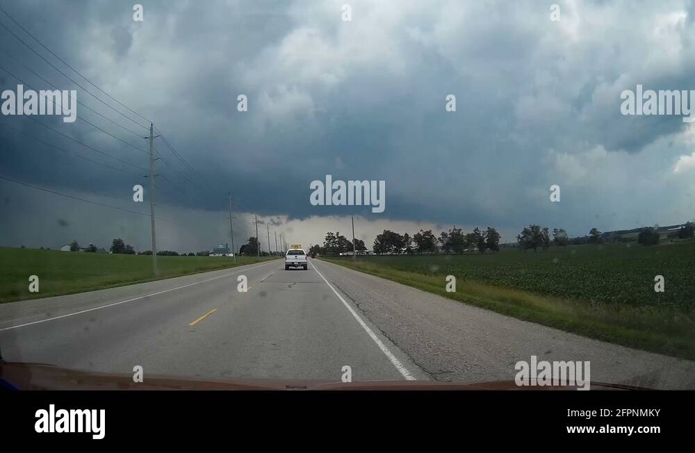 Driving into severe thunderstorm, dark clouds and heavy rain POV shot ...
