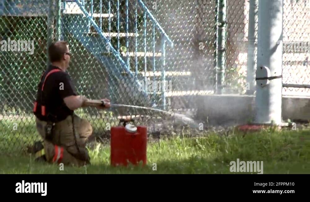 Fireman using backpack fire pump to extinguish grass fire Stock Video ...