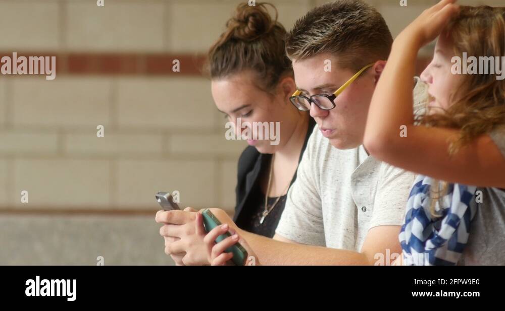 Friends (students) using their smart cell phones in school. Ultra HD 4K ...