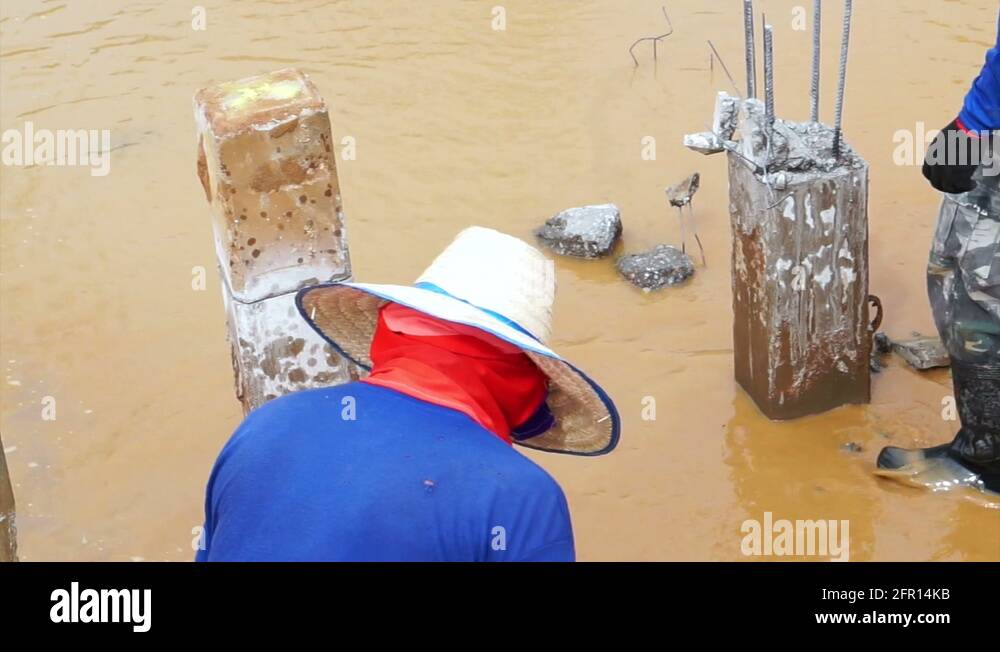 construction worker manually pull down, dismantling concrete column in ...