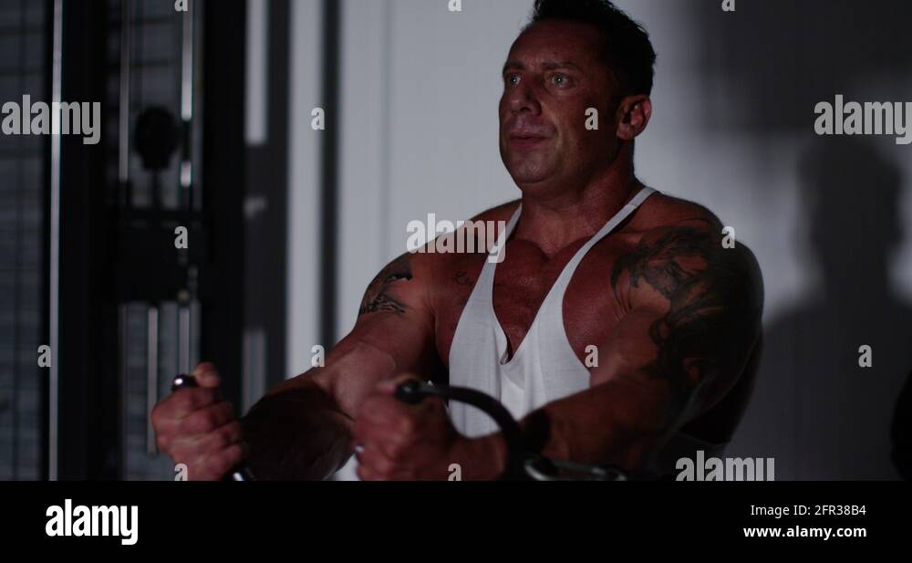 Athlete muscular bodybuilder training on a cable crossover fly pulley ...