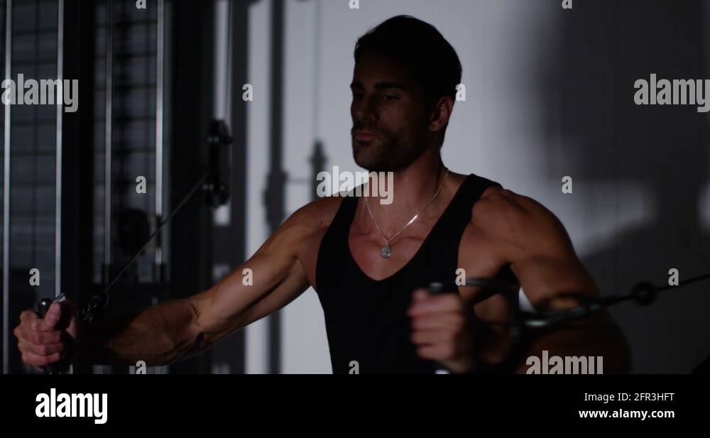 Athlete muscular bodybuilder training on a cable crossover fly pulley ...