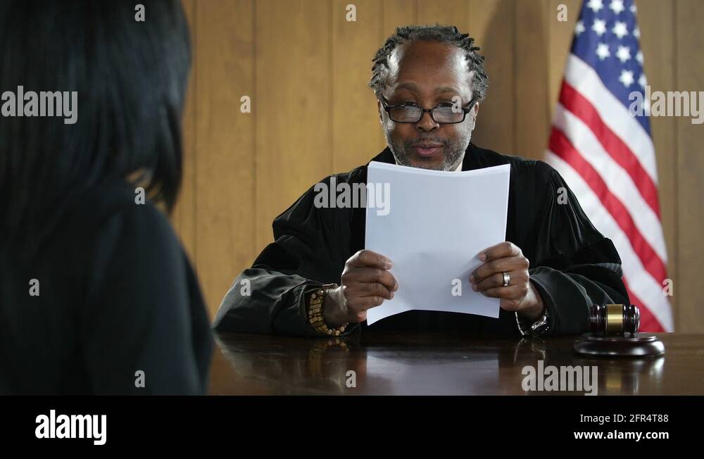 Black male judge reading a verdict to black woman in court Stock Video ...