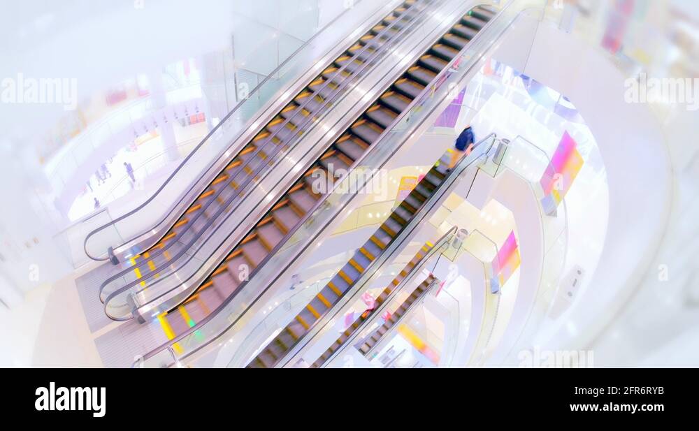 Loopable video of people moving fast on escalators in modern shopping ...