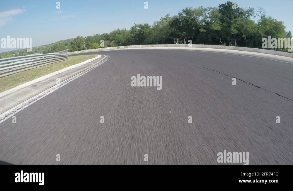 LOW ANGLE VIEW: Race car competing and driving fast on race track lap ...