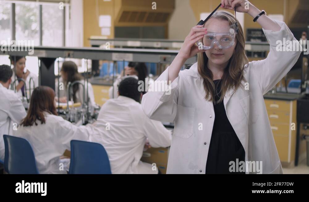 student in a science lab putting on safety goggles and smiling Stock ...