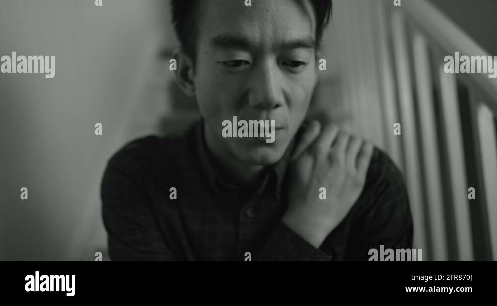 Portrait of a sad man sitting on a staircase looking into camera Stock ...