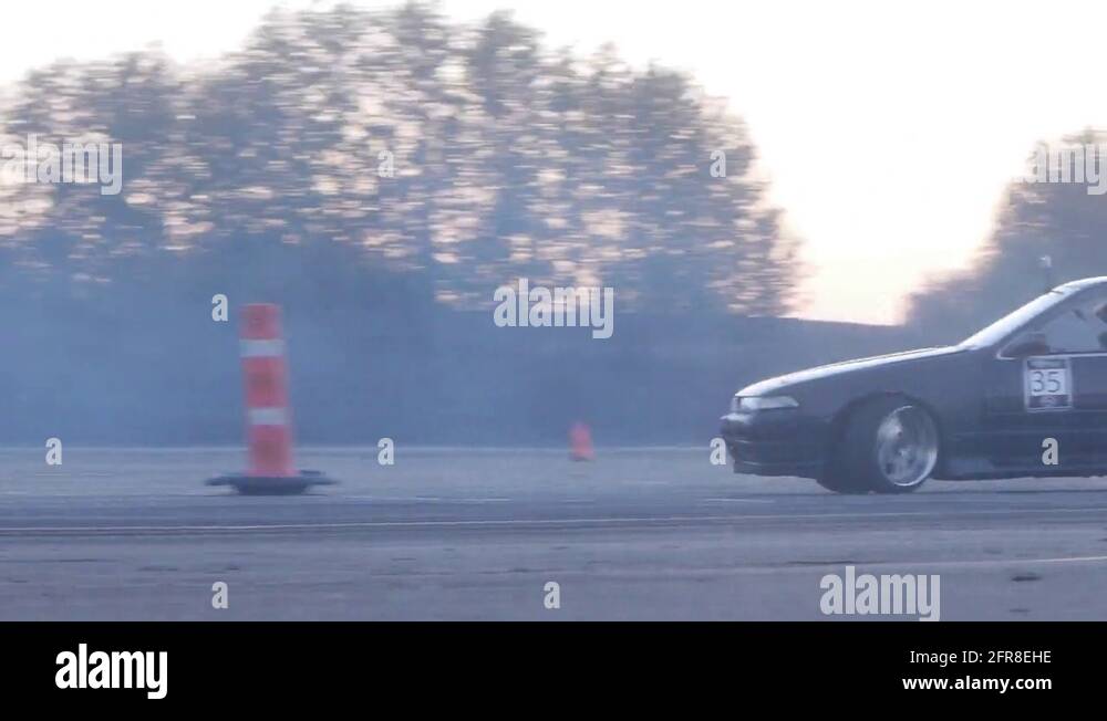 Two cars drift side by side around a corner on closed race track Stock ...