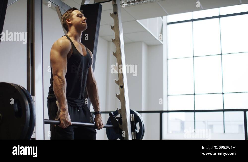 Muscular athlete using heavy weights bar in the gym Stock Video Footage ...