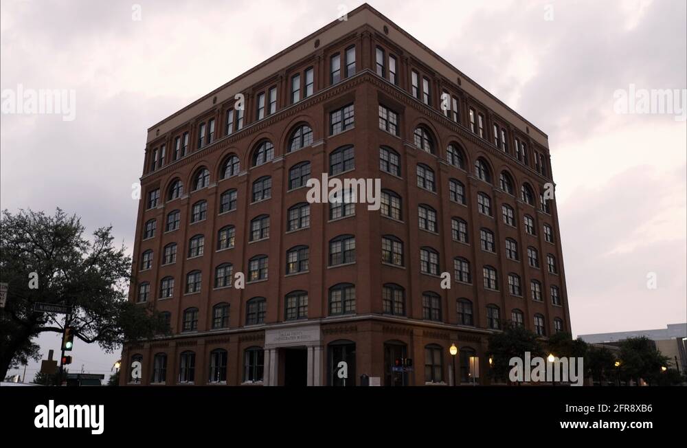 Tilting down shot of the Texas School Book Depository at Dealey Plaza ...