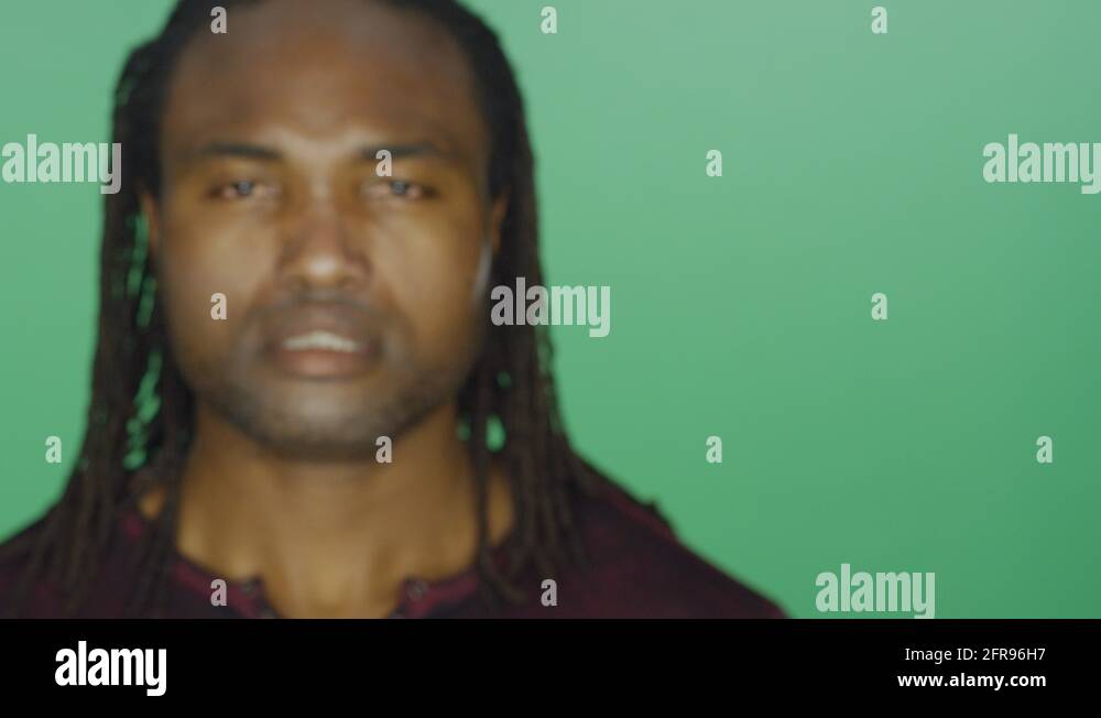 black man with dreads frowning and snarling, on a green screen ...