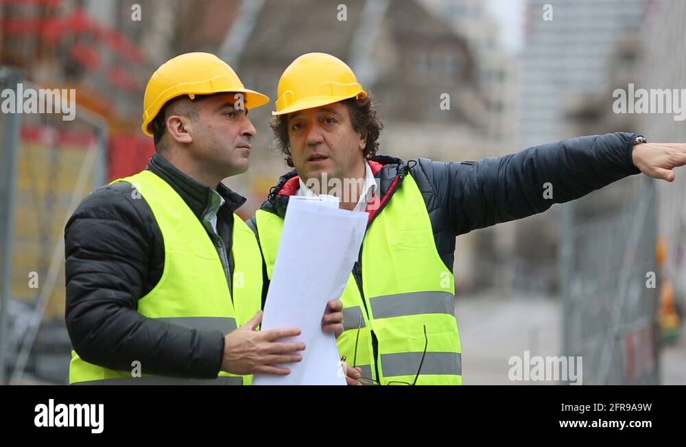 Architects checking office blueprints pointing at something on ...