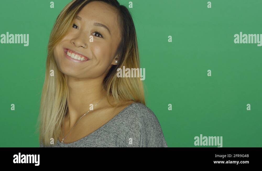 Cute Asian girl smiling, on a green screen studio background Stock ...