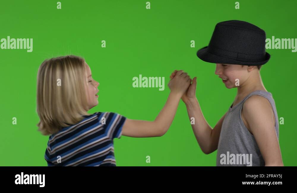 Two kids giving high five to each other in front of greenscreen Stock ...