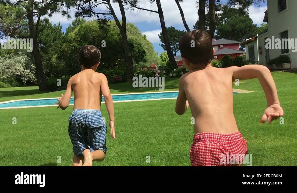 Children running and jumping to the swimming pool water. Kids sprinting ...