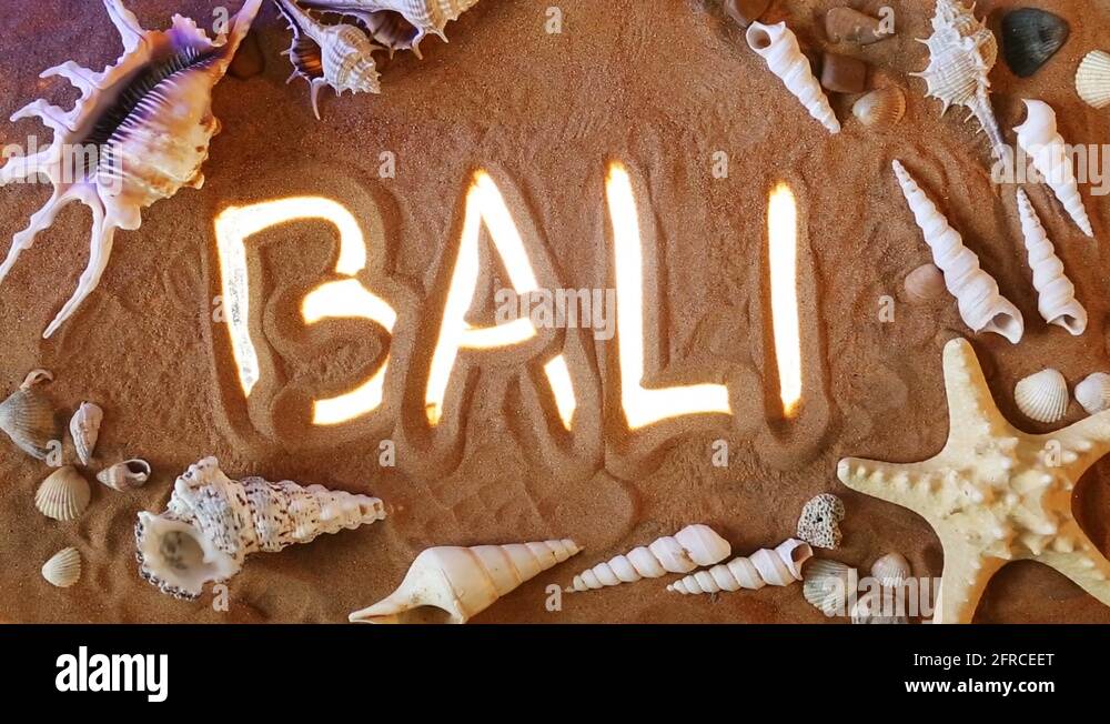 Hand drawing Bali symbol in the sand. Beach background. Top view Stock ...