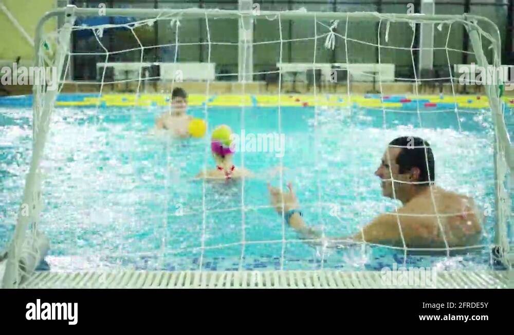 Father and two children play water soccer in indoor pool Stock Video ...