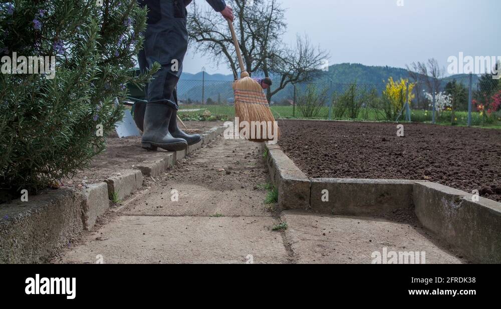 Sweeping a garden path and clearing it of soil Stock Video Footage - Alamy